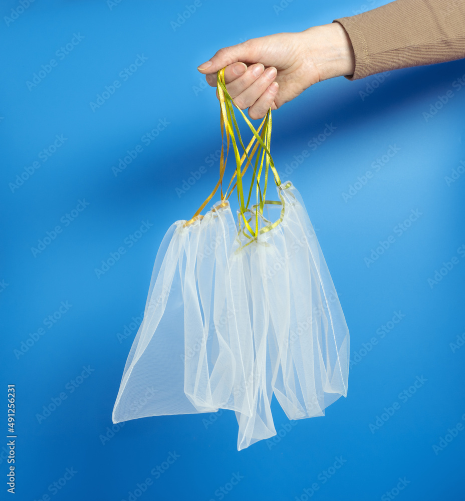 Hand holding empty reusable produce bags, diy from textile, reusable ...