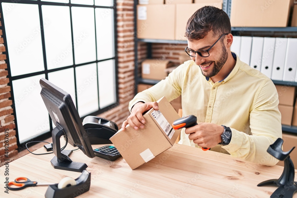 Young hispanic man ecommerce business worker scanning label using ...