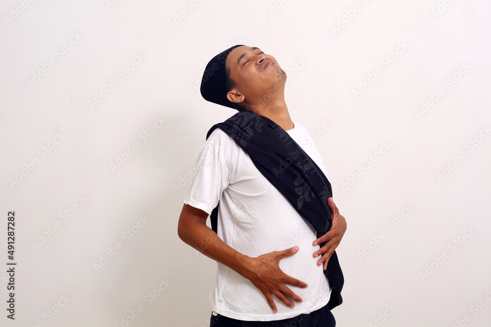 Asian man feel very full after eating too much food. The man holds his ...