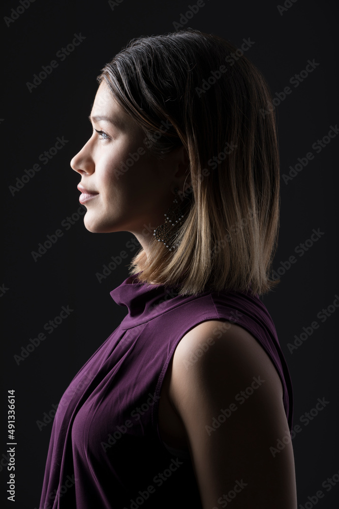 Profile of woman against black background Stock Photo | Adobe Stock