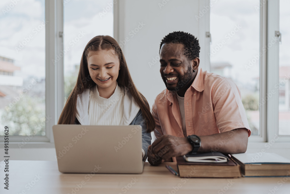 Caucasian girl learning online class from home with family. little cute ...