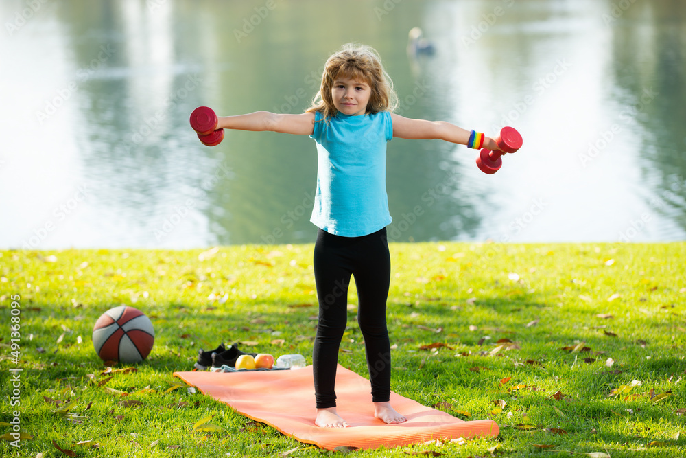 Kids sport. Healthy kid boy with dumbbell exercise outdoor. Little ...