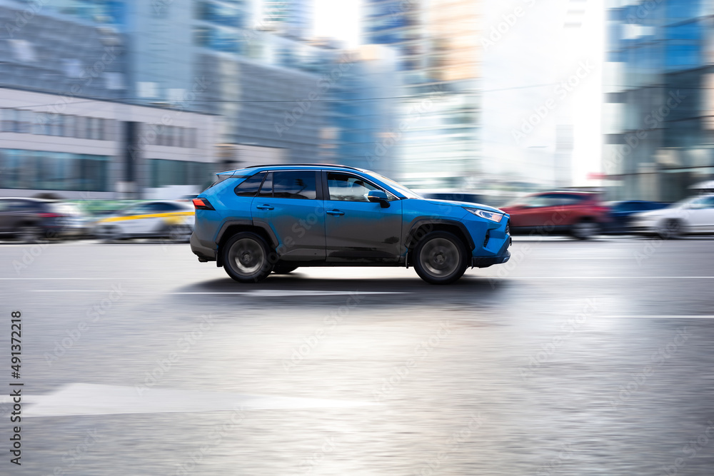 Toyota RAV4 XA50 SUV car on the city road. Fast moving blue crossover ...