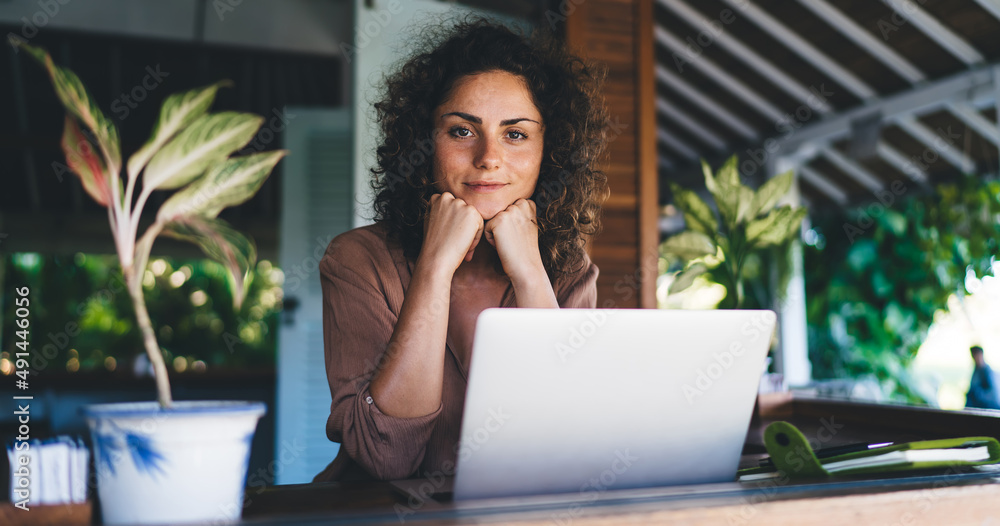 Portrait of millennial female IT professional with modern laptop device ...