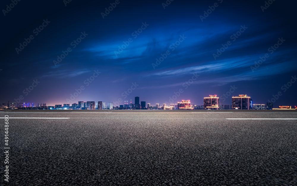 The night view of the city in front of the asphalt road Stock Photo ...
