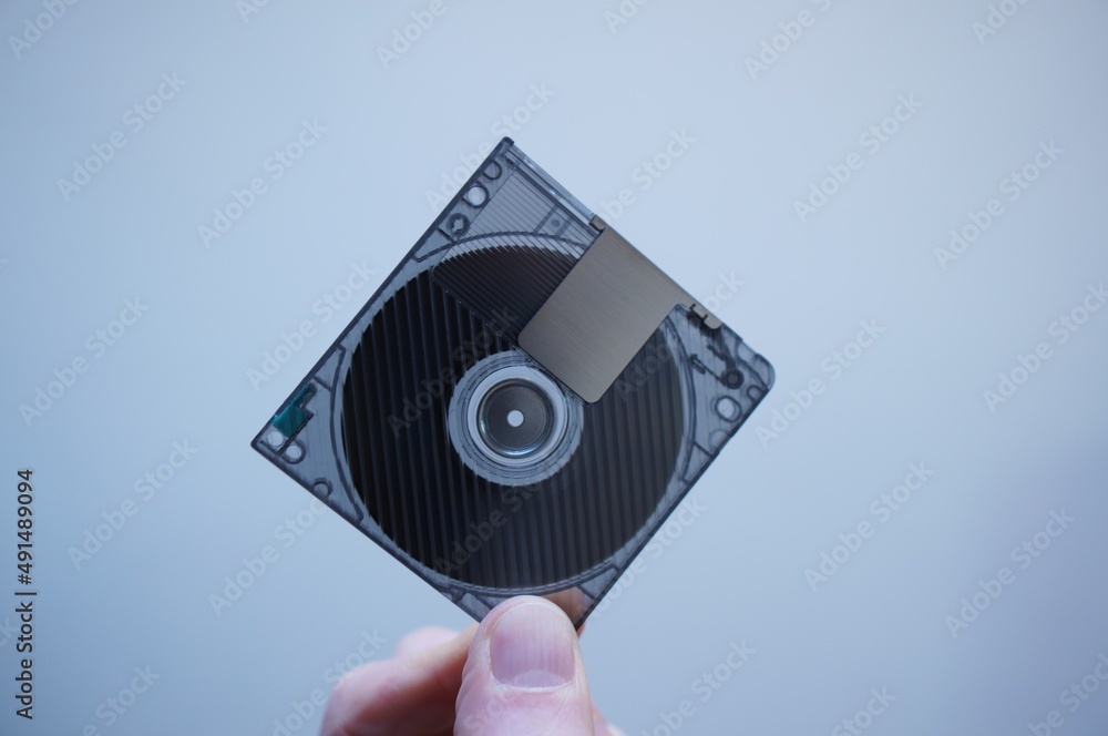 Caucasian hand holding a minidisc. Minidisc back. Reverse side of ...