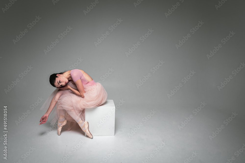 young pretty, fragile, beautiful ballerina sits tired, tortured in a ...