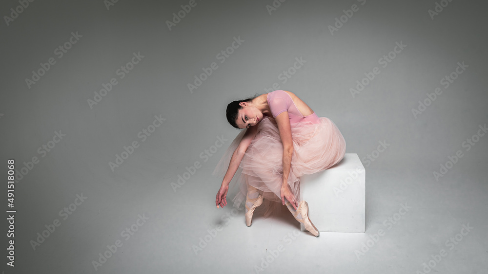 young pretty, fragile, beautiful ballerina sits tired, tortured in a ...