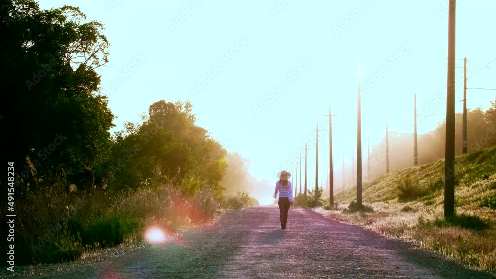 Vidéo Stock Woman walking away into distance on road near forest ...