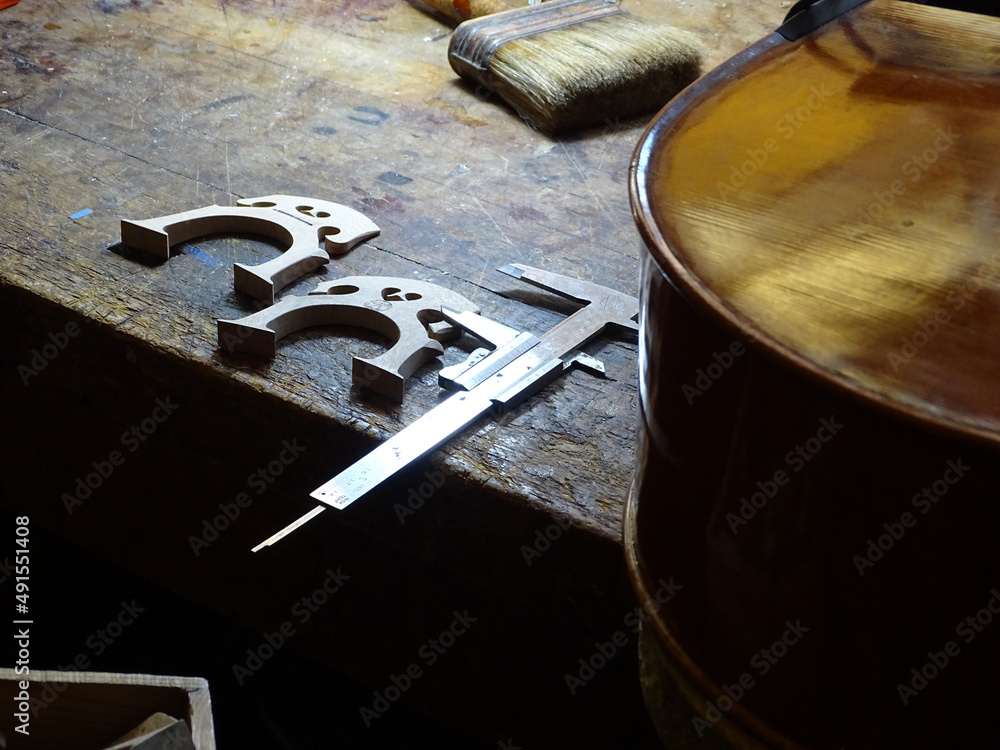 luthier working in his workshop selecting a bridge for a cello Stock ...