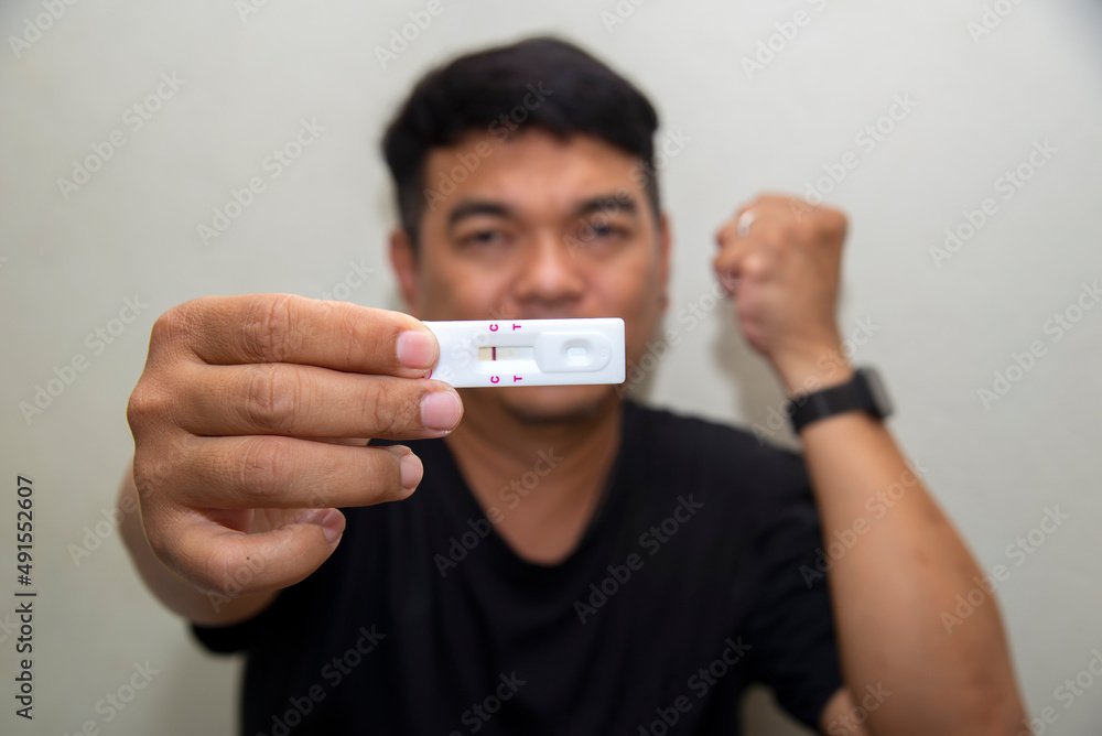Man holding Covid-19 negative test result with SARS CoV-2 Rapid antigen ...