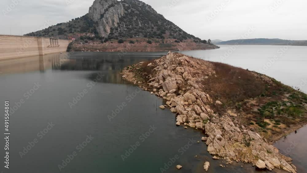 Aerial footage flying over a small, lonely island in a reservoir ...