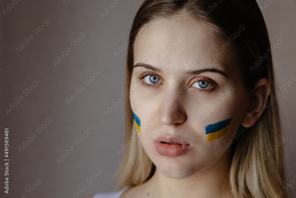 The face of a girl white the national flag of Ukraine yellow-blue on ...