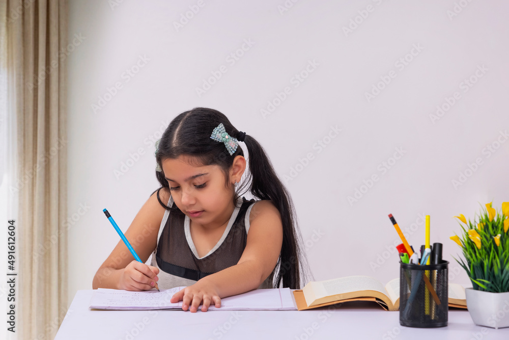 Pretty little girl doing homework at home Stock Photo | Adobe Stock