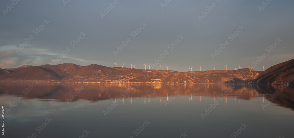 Cinematic look of Danube river nature landscape at sunset. Wind turbine ...