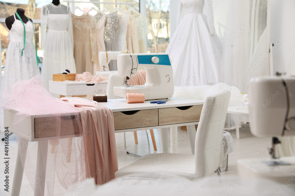 Dressmaking workshop interior with wedding dresses and equipment Stock ...