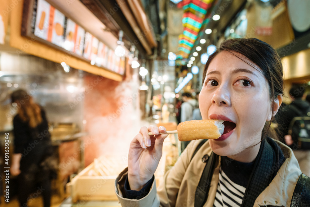hungry female tourist opening mouth wide is eating japanese traditional ...
