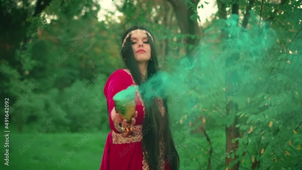 fantasy woman witch sorceress holds in hands magic cup with love potion ...