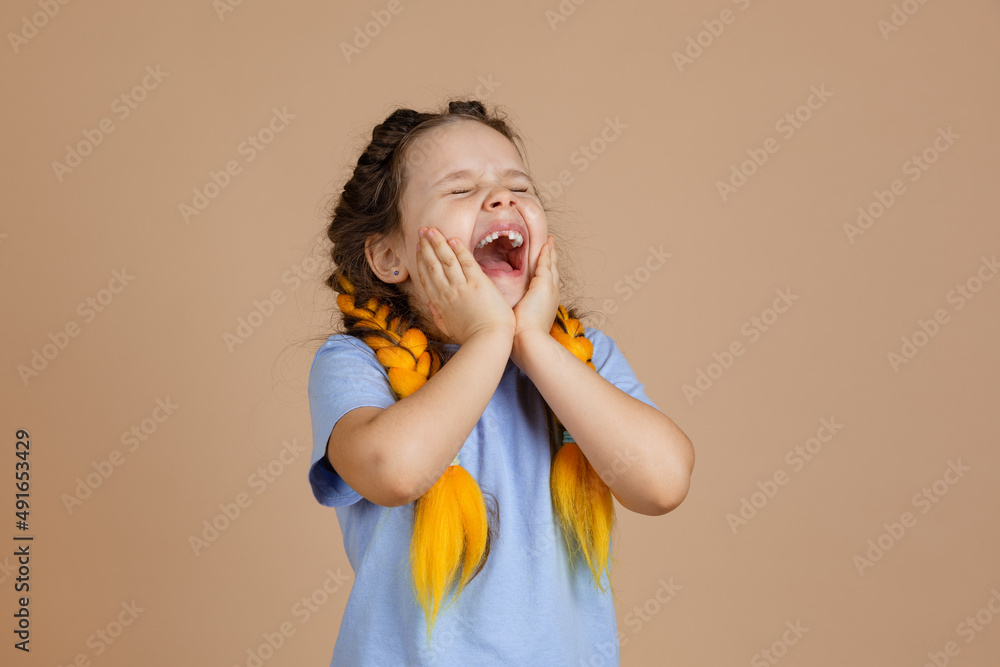 Shouting, sad young girl with opened mouth touching face with hands ...
