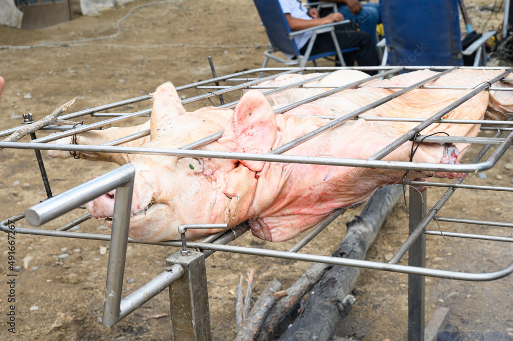 Grilled pig at the street food festival. Roasted pig on the rack. Food ...