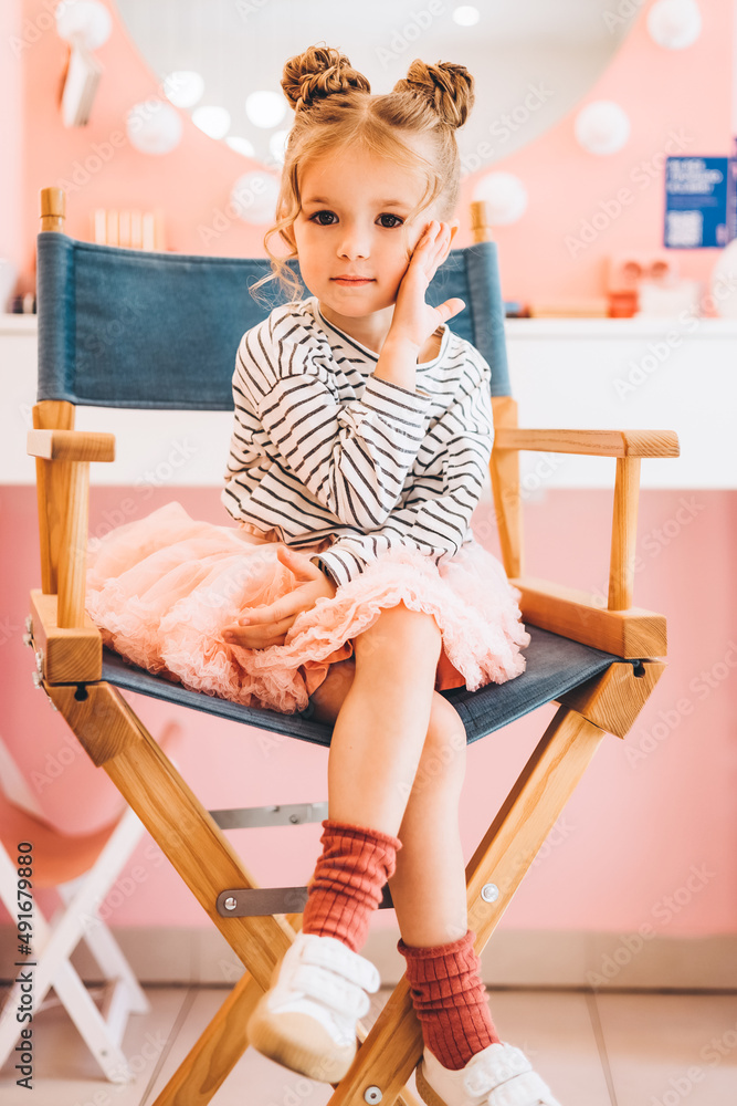 Stylish little girl in a beauty salon for children where she made a ...