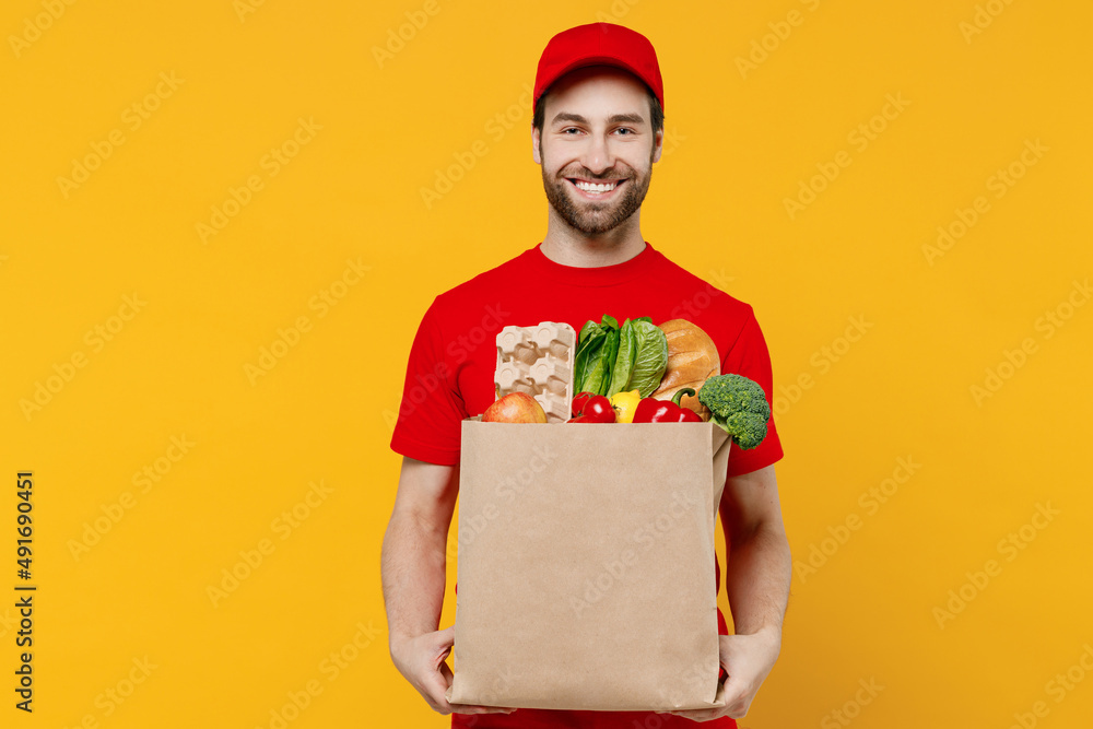 Smiling delivery guy employee man 20s wear red cap T-shirt uniform ...