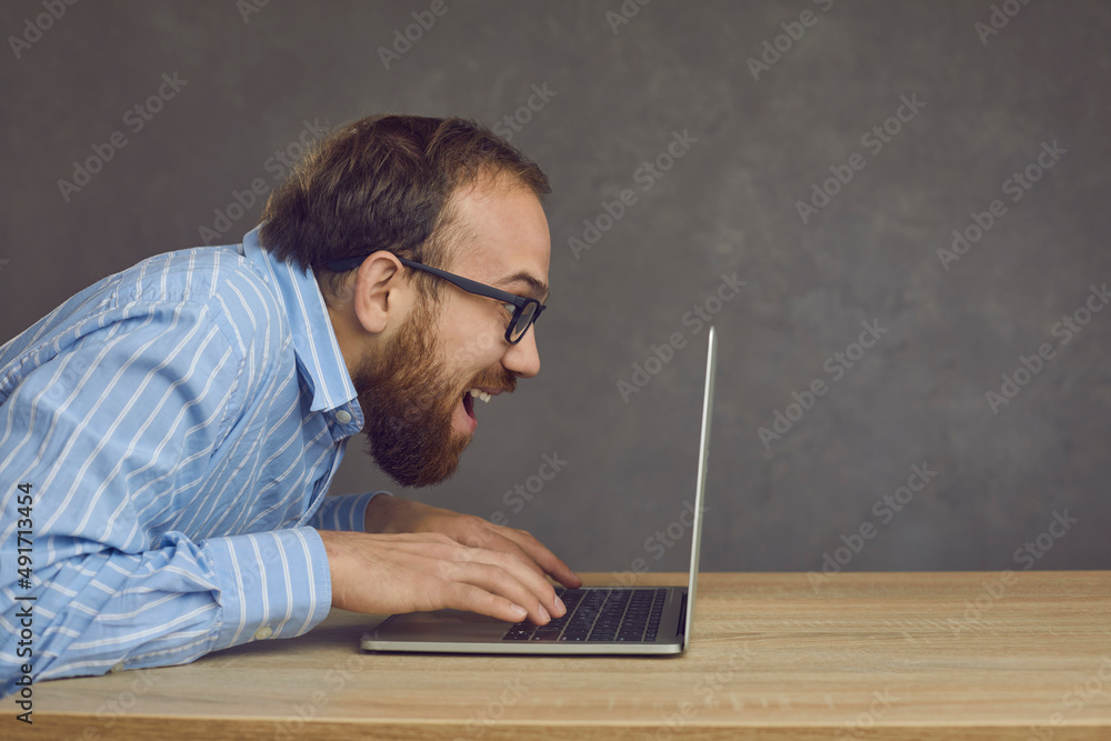 Funny caucasian man typing fast on laptop keyboard, male gamer playing ...