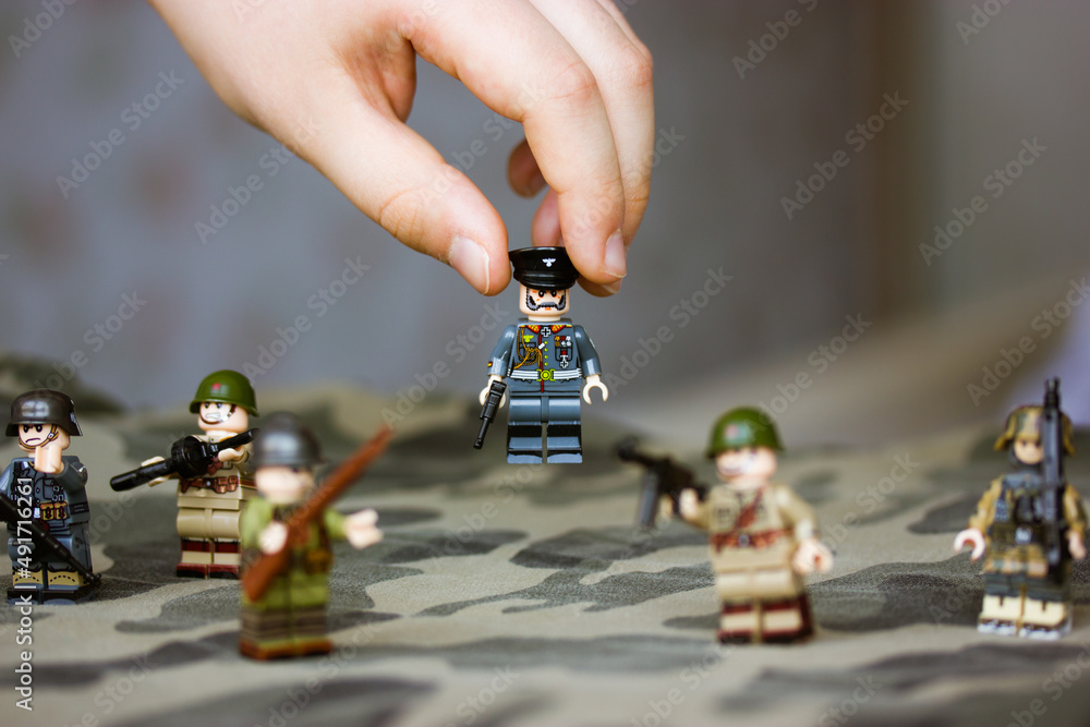 Kyiv, Ukraine. March 9, 2022. Figurine of officer in child's hand. A ...
