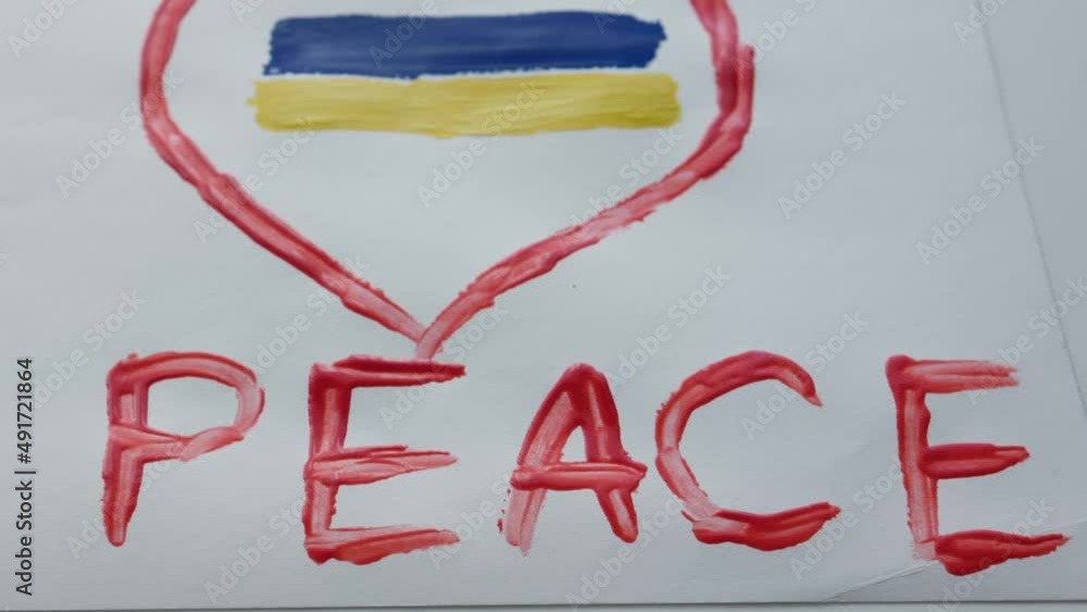 painting yellow blue Ukraine flag with drawing red heart around symbol ...