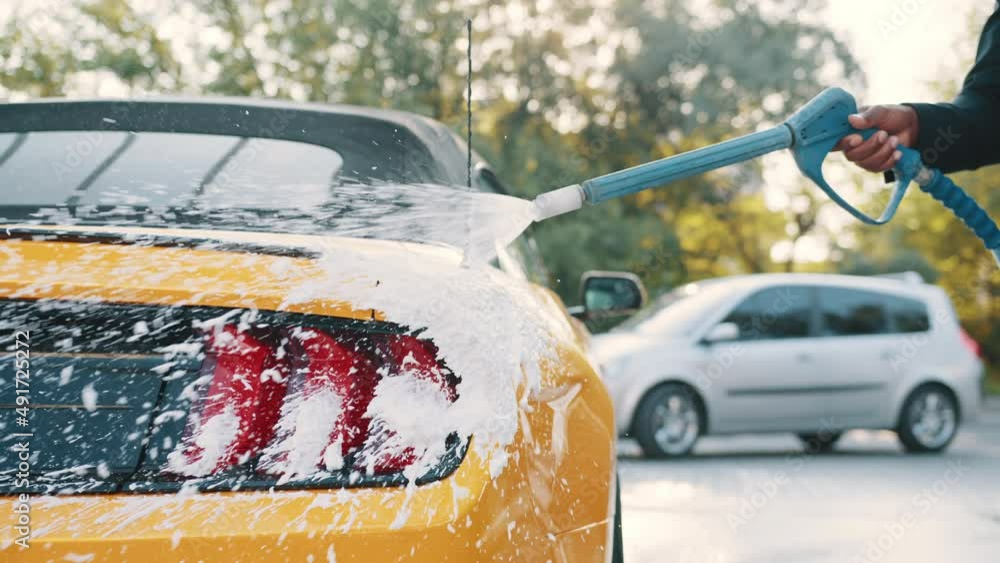 Car wash outdoors concept. Yellow car in foam. Car getting a wash with ...