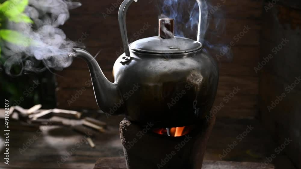 boiling water in cattle on charcoal fire stove Stock ビデオ | Adobe Stock