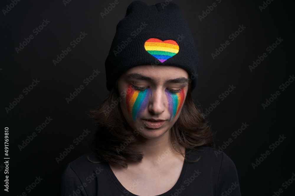 Portrait young crying woman with painted LGBT flag on her cheek. Crying ...