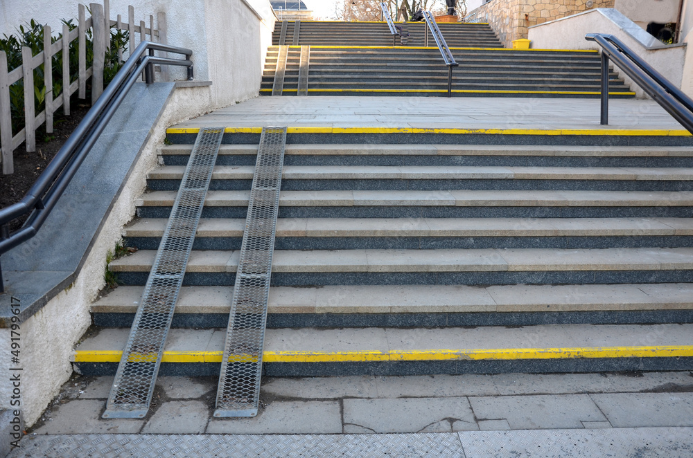 ramp combined with a gray concrete staircase and railings specially ...