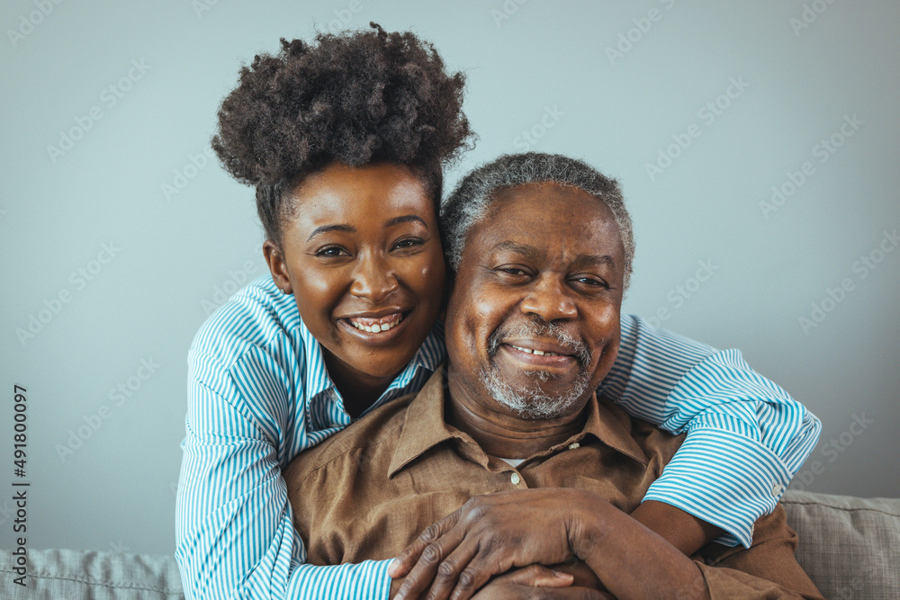 Senior man and his middle aged daughter smiling at each other embracing ...
