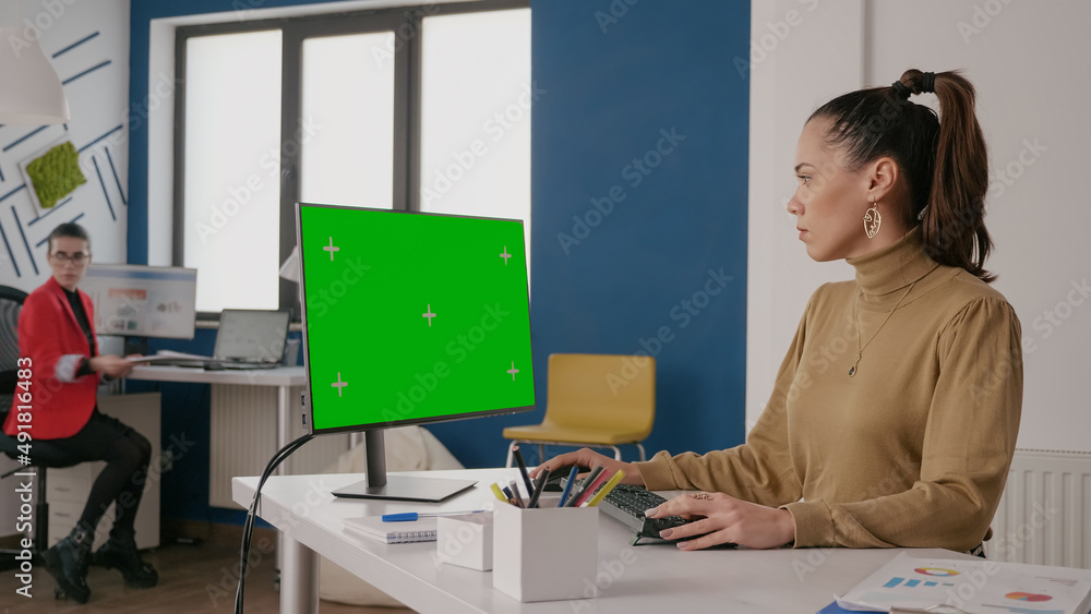 Business woman looking at green screen on computer, using isolated ...