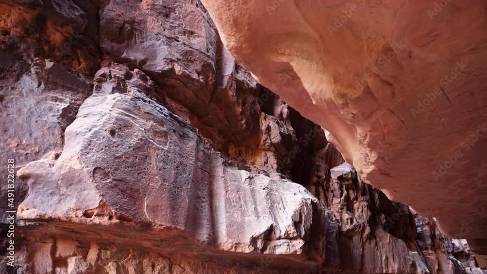 Interior of a red granite cave in the desert with inscriptions and rock ...