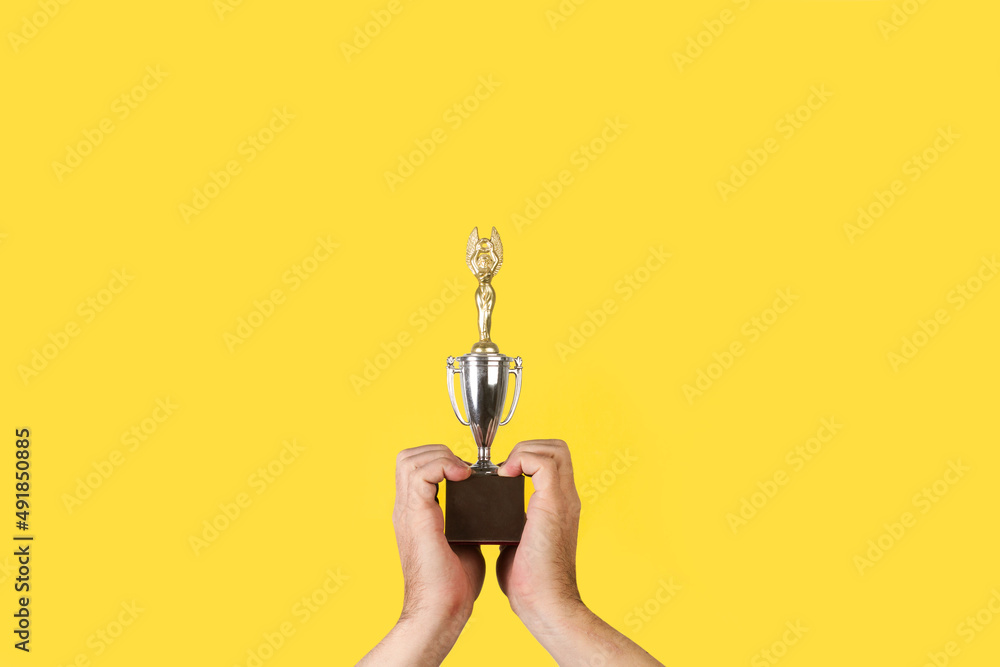 Manos de hombre sosteniendo y levantado un trofeo sobre un fondo ...