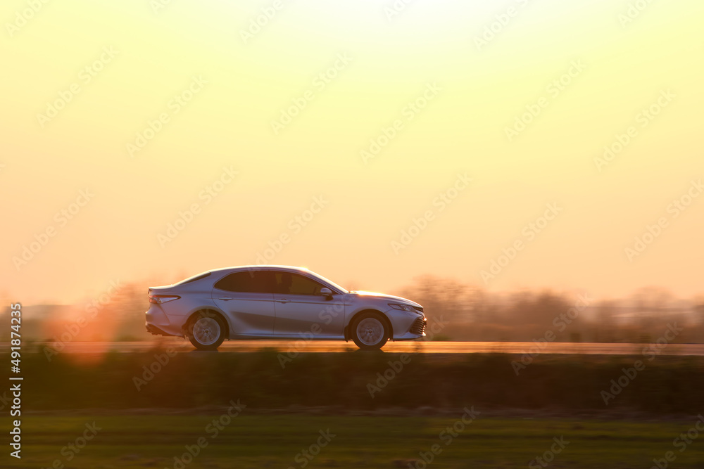 Car driving fast on intercity road at sunset. Highway traffic in ...