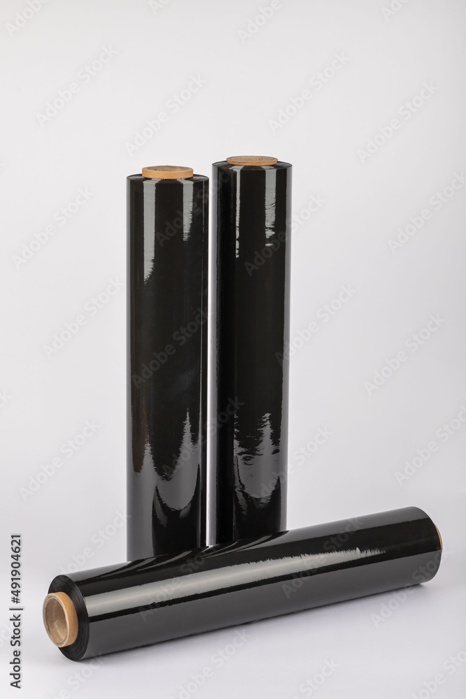 roll of plastic cling film with black wrap. It stands in an isolated ...