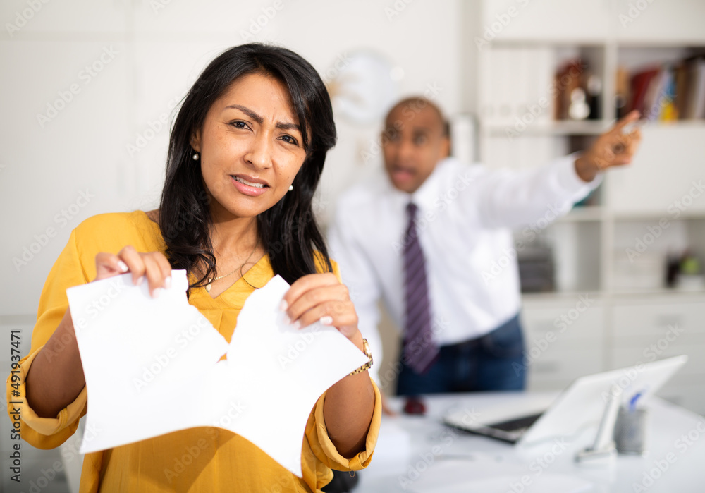 Foto de Upset female office employee tearing piece of paper, trying to ...