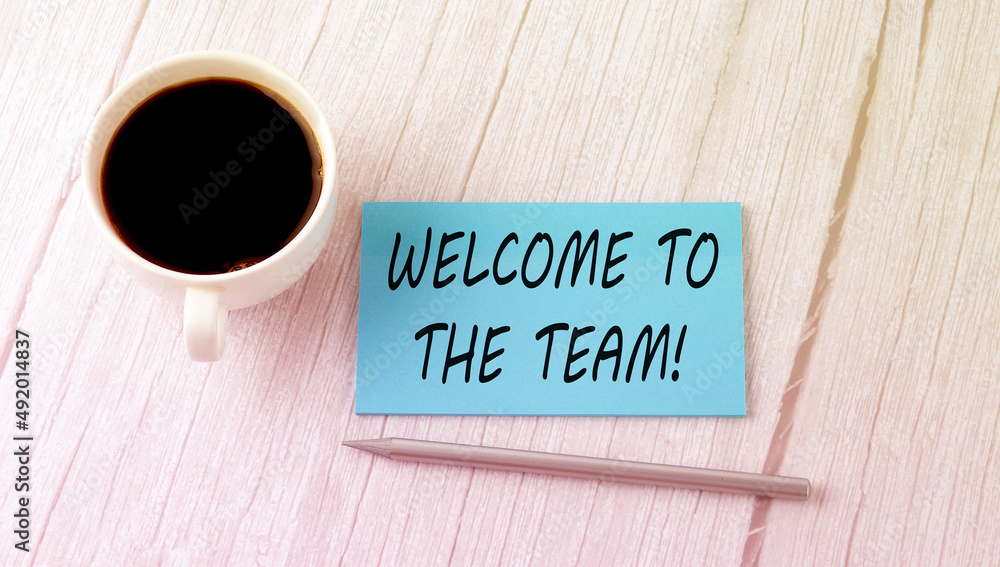 WELCOME TO THE TEAM text on the blue sticker with cofee and pen Stock ...