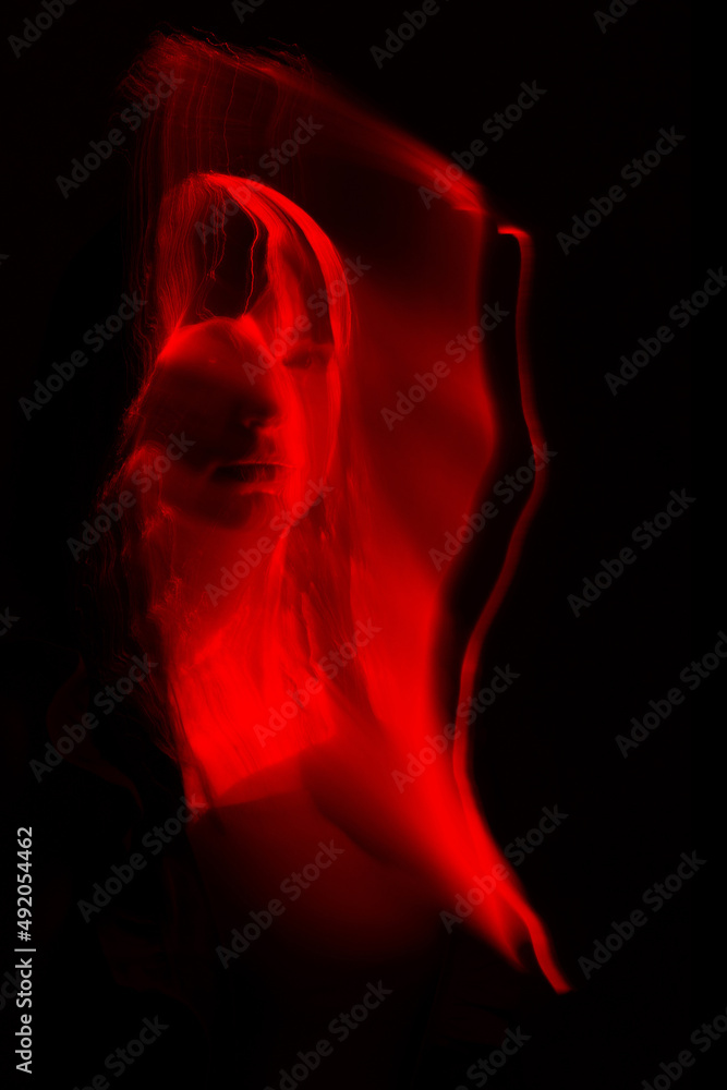 Abstract woman silhouette in light trails of light painting with red ...