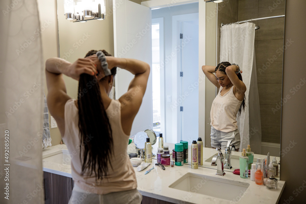Teenage girl getting ready in bathroom mirror Stock Photo | Adobe Stock