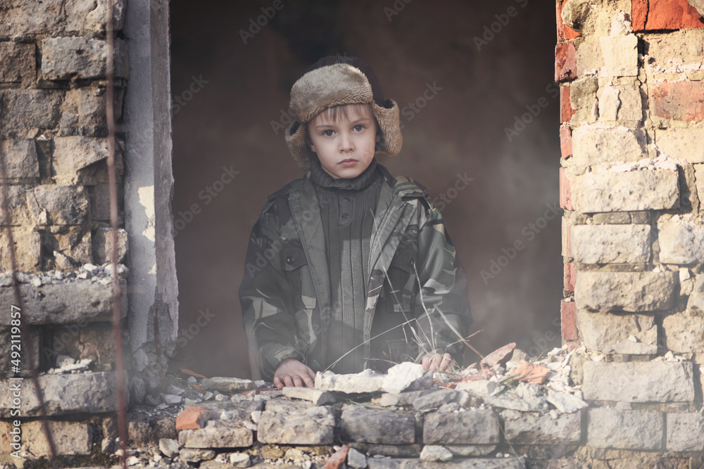 War and the child. Little scared boy in the ruins of the house ...