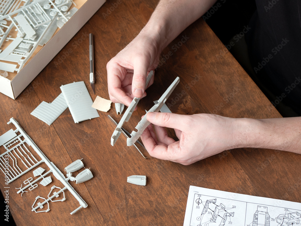 Plastic model builder is slapping a model together. Assembling the ...