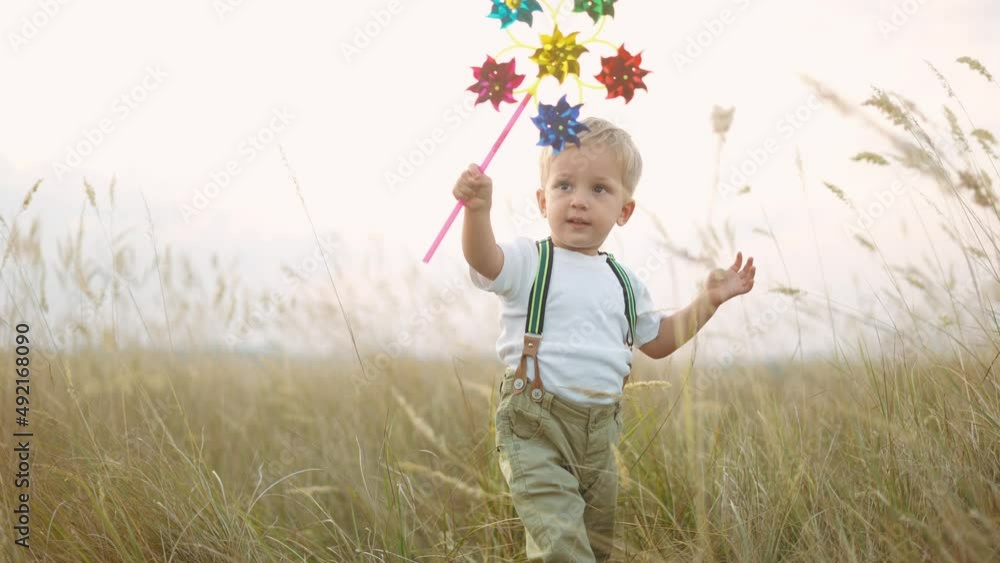 kid walk pinwheel. little baby boy play with windmill toy wind in the ...