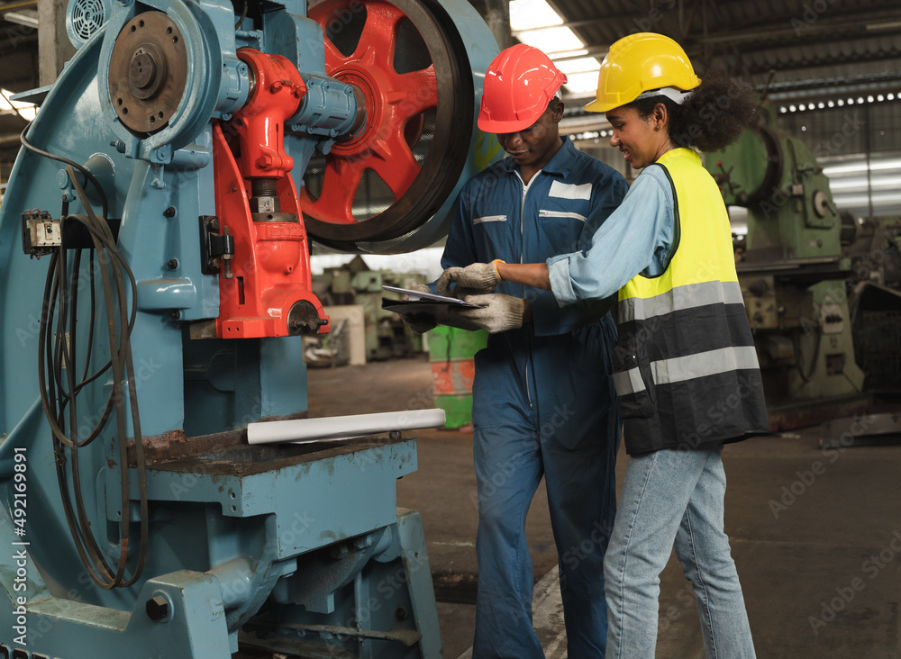Engineer woman and mechanic hard work with machine at factory Stock ...