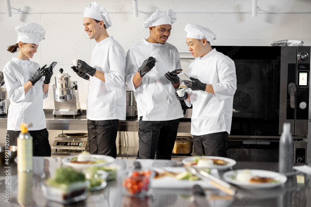 Team of multiracial cooks having conversation during a coffee break in ...