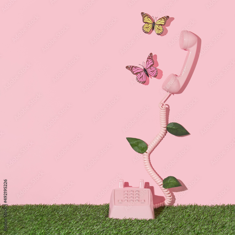Spring creative layout with pink retro phone with butterflies and ...