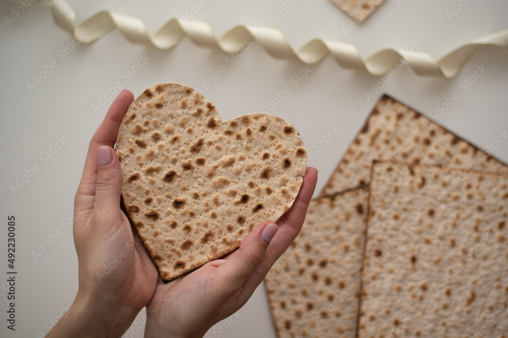 Woman's hand holds Matzah shape of heart. Traditional of Jewish Holiday ...